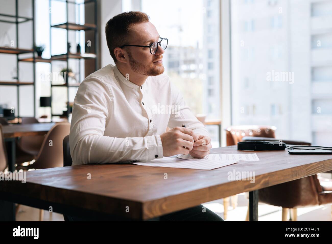 Handsome talented composer wearing stylish eyeglasses writing musical ...