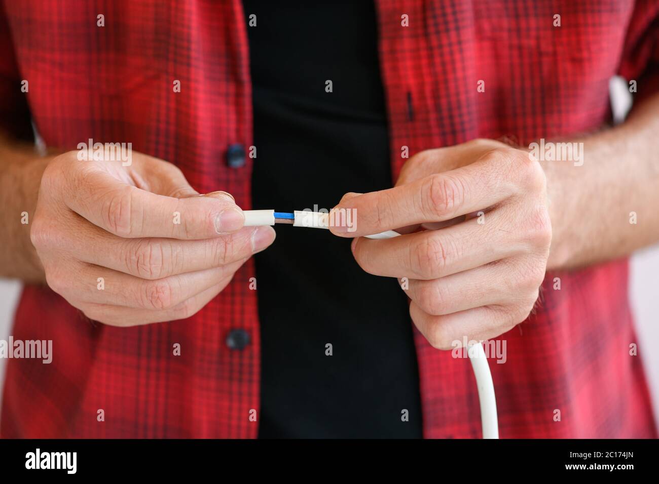 Male hands connect electric wires close up Stock Photo - Alamy