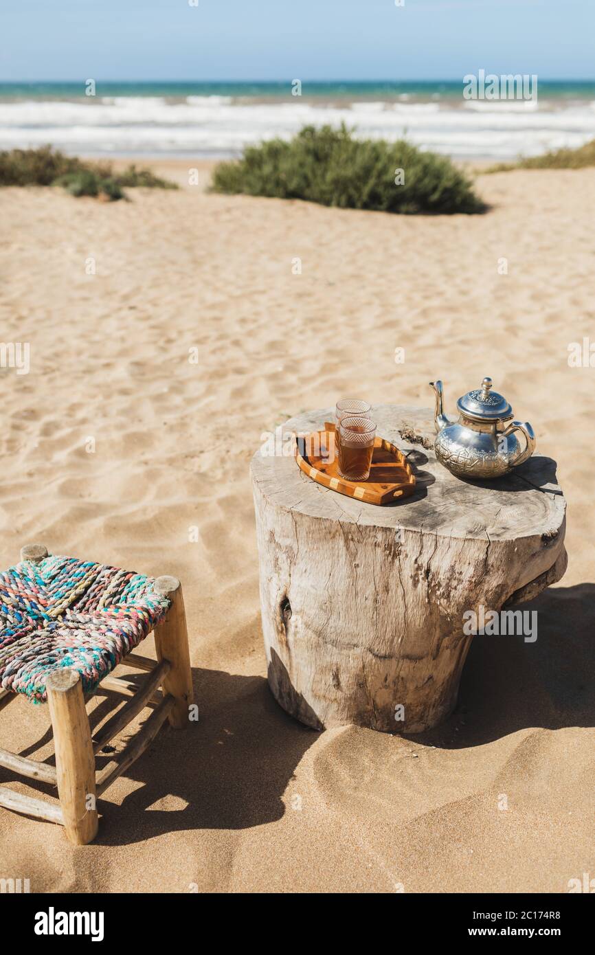 Traditional moroccan mint tea and old silver teapot on wooden table ...