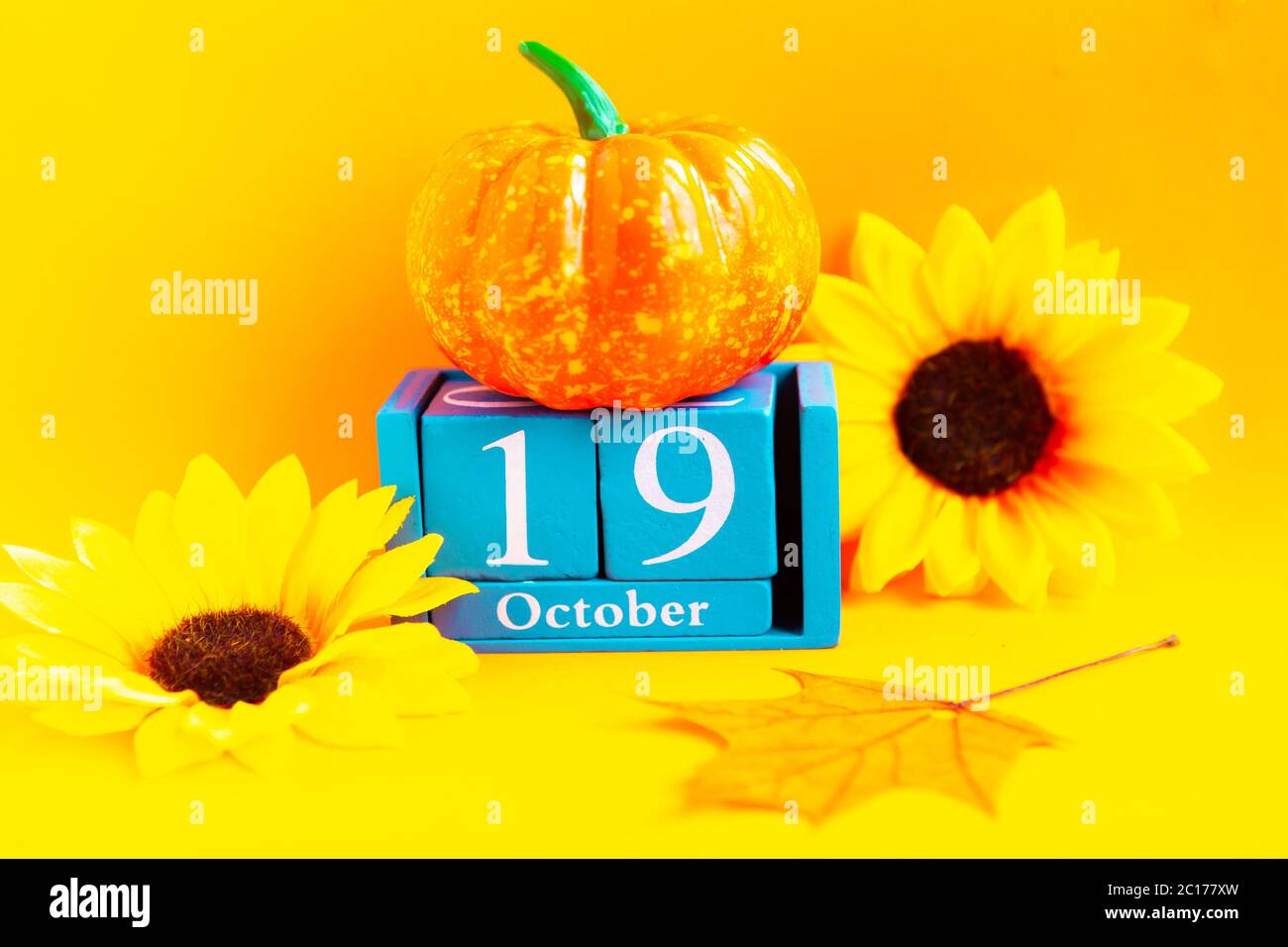 October 19th. Wooden cube calendar with month and date on bright orange ...