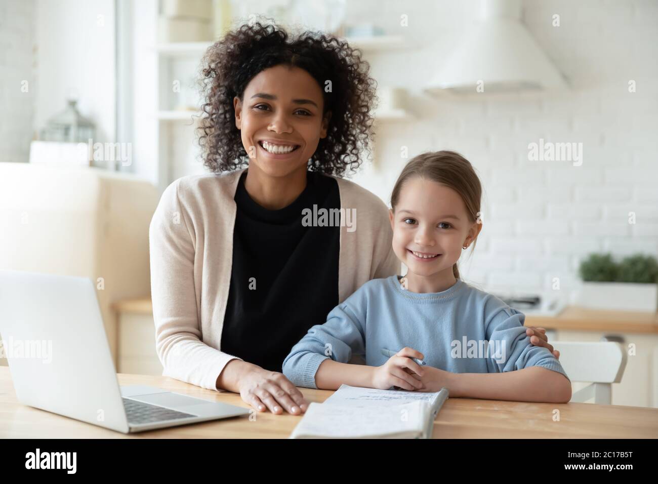 Happy tutor and smart little learner schoolgirl portrait Stock Photo ...