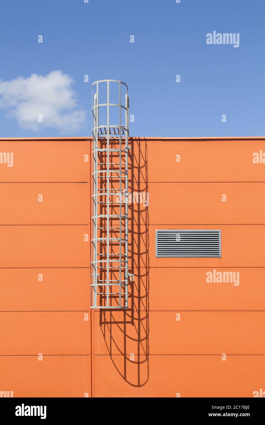 Modern industrial building wall with metal ladder Stock Photo - Alamy