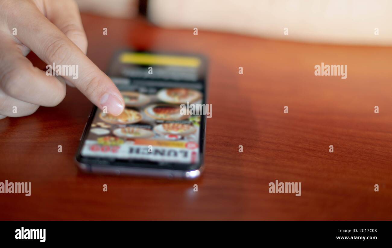 Female hand scanning the QR code with mobile phone for order foods and ...