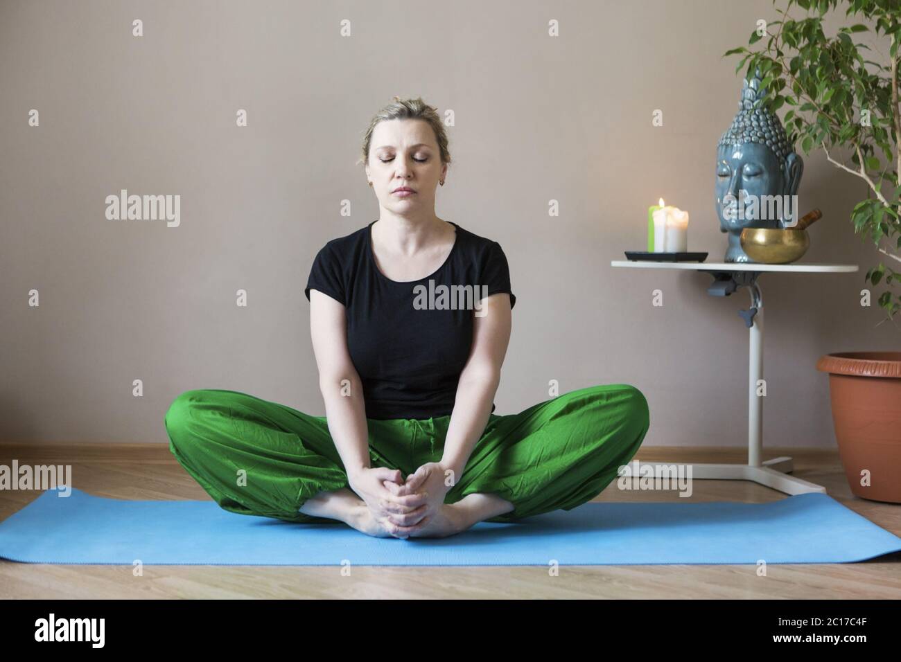 Middle aged woman doing yoga indoors Stock Photo - Alamy