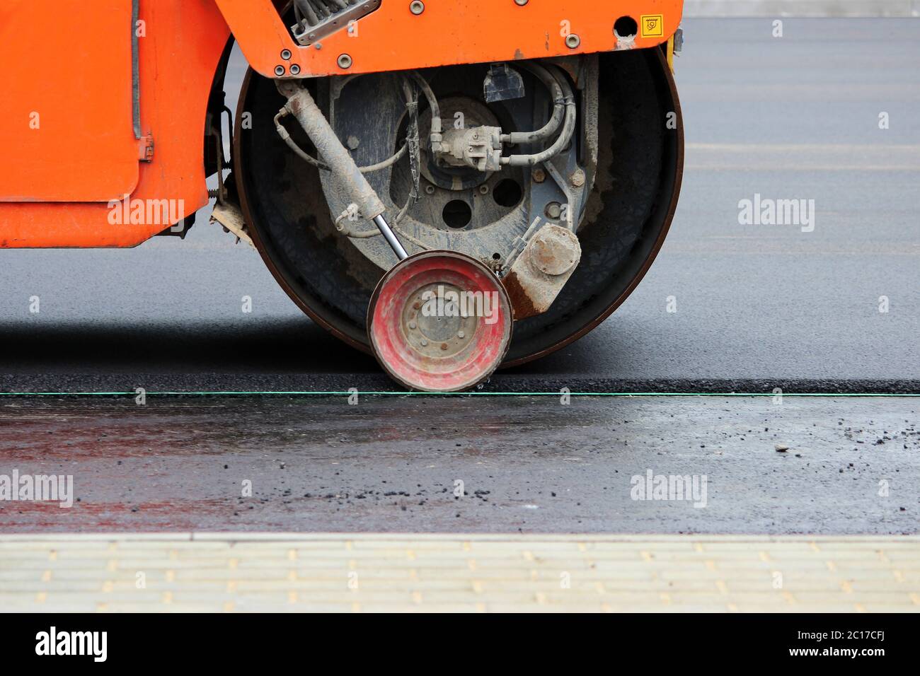 Heavy compactor tires the upper layer of asphalt in the construction of ...