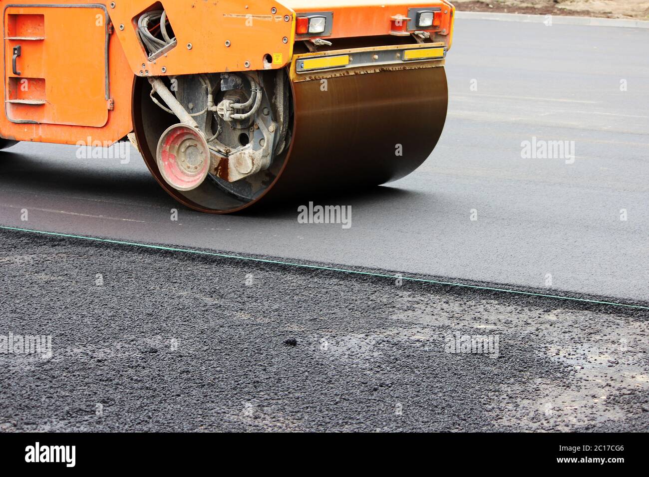 Heavy compactor tires the upper layer of asphalt in the construction of ...