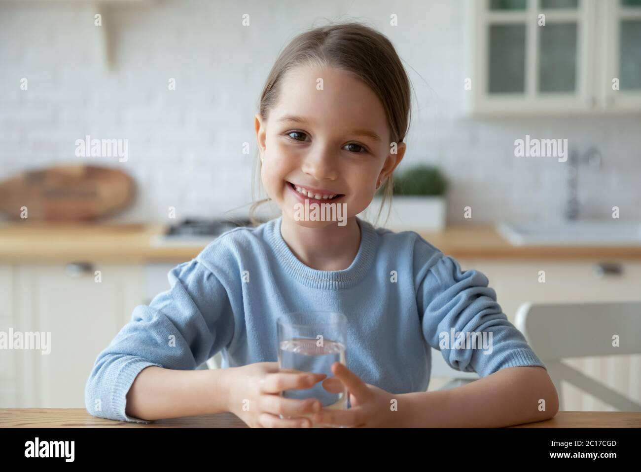 Headshot portrait little girl holding glass of still water Stock Photo - Alamy