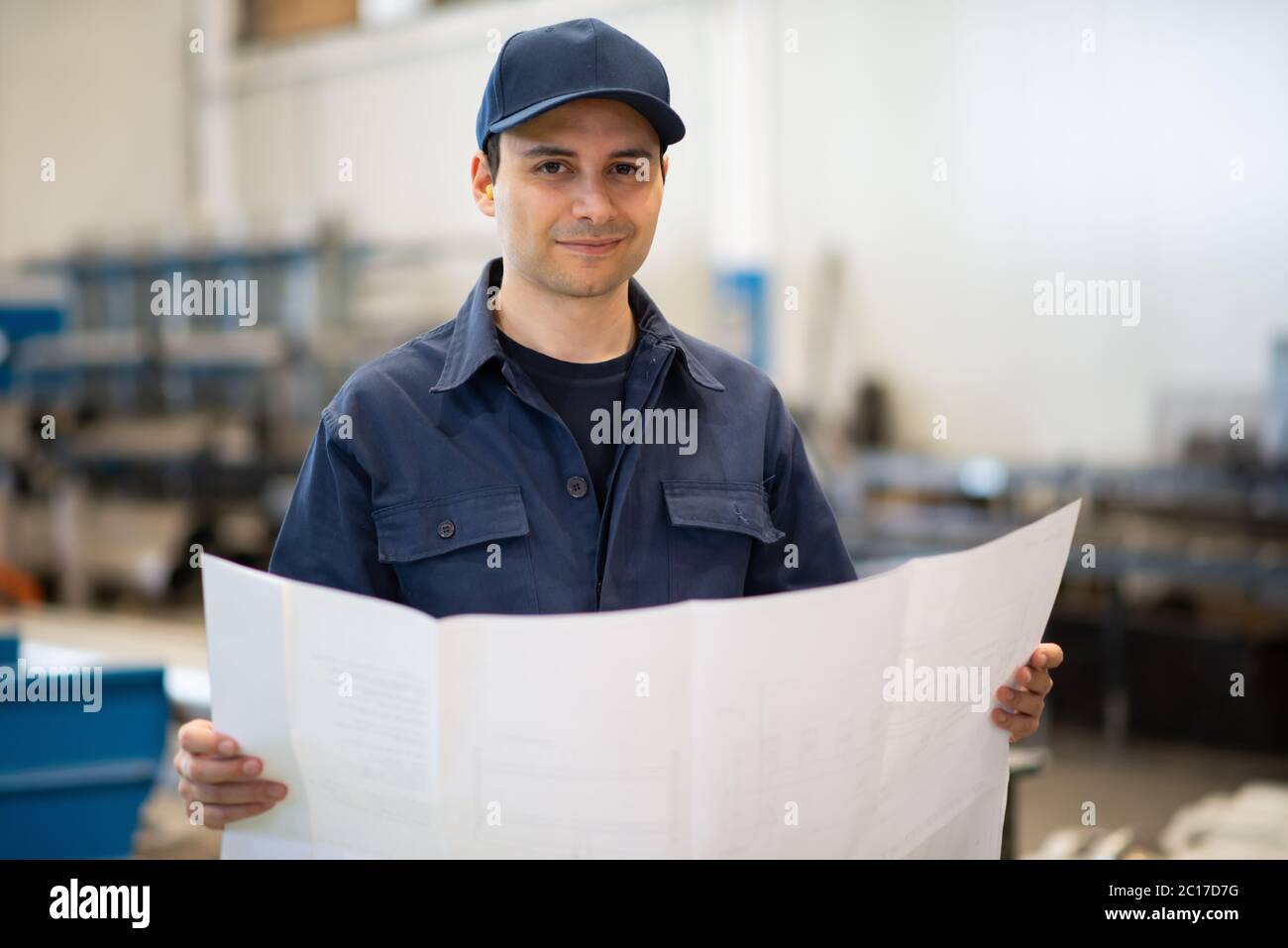Blue dressed engineer reading a bluepring drawing in an industrial ...