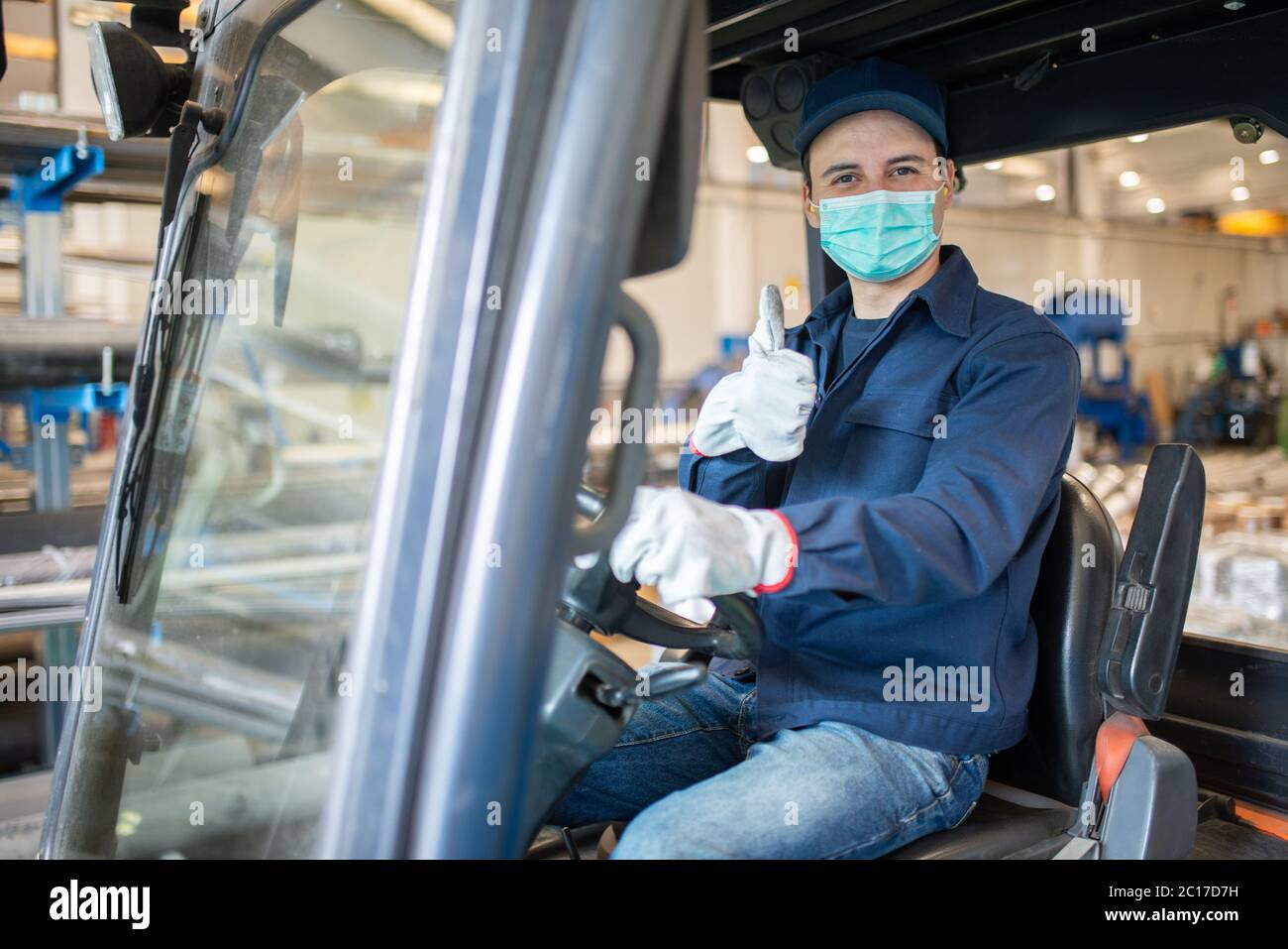 Worker using a forklift, driver at work in an industrial factory Stock ...
