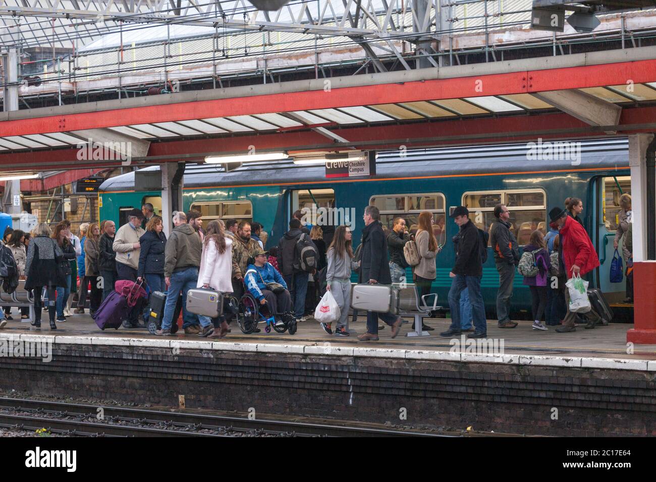 Rail passengers at Crewe railway station boarding and alighting from a ...