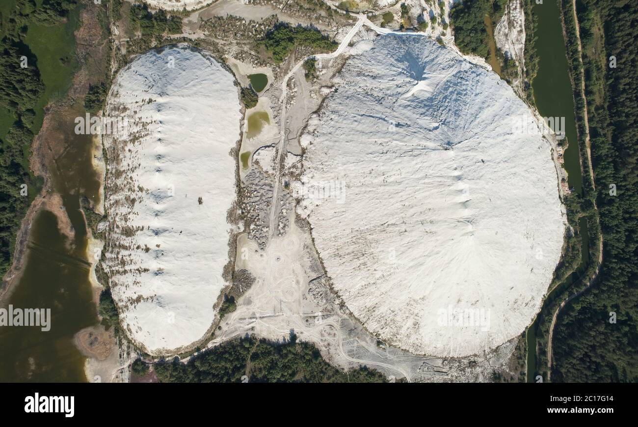 Waste hills around forest above top drone top view Stock Photo - Alamy