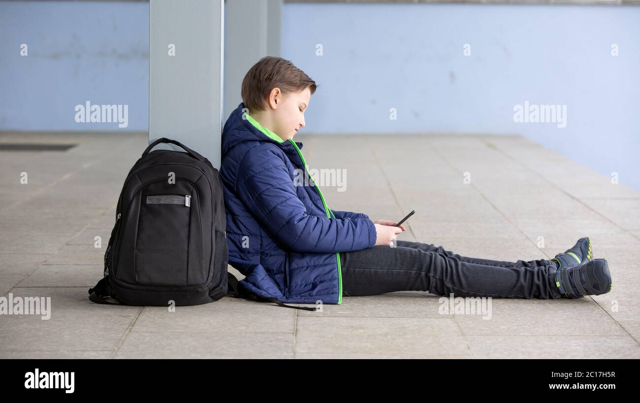 Truancy concept, young boy staying away from the school and playing ...