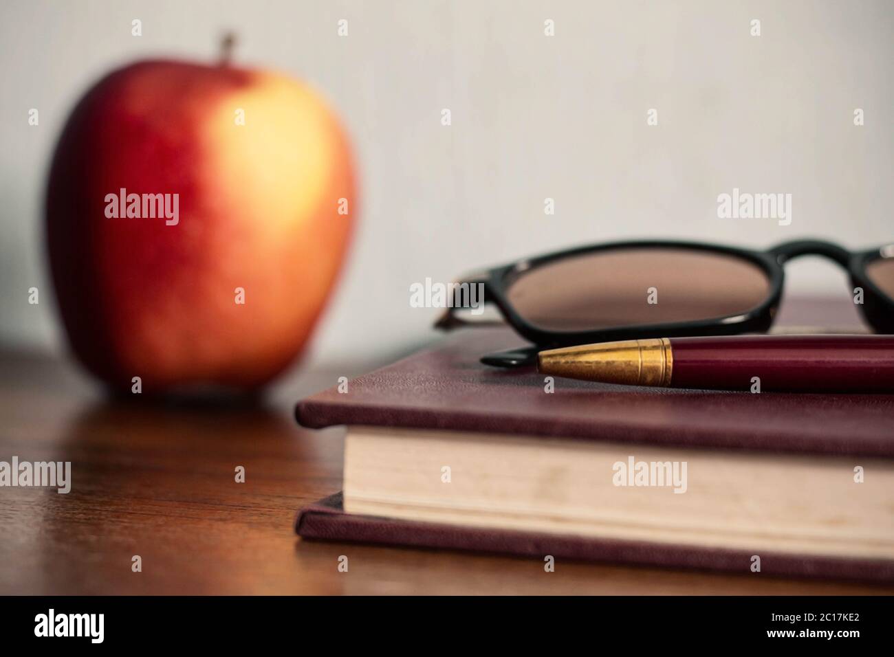Pen and books on desk Stock Photo - Alamy