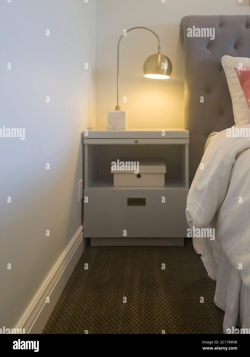 Modern lamp on top of white wood bed side table with storage drawer and ...