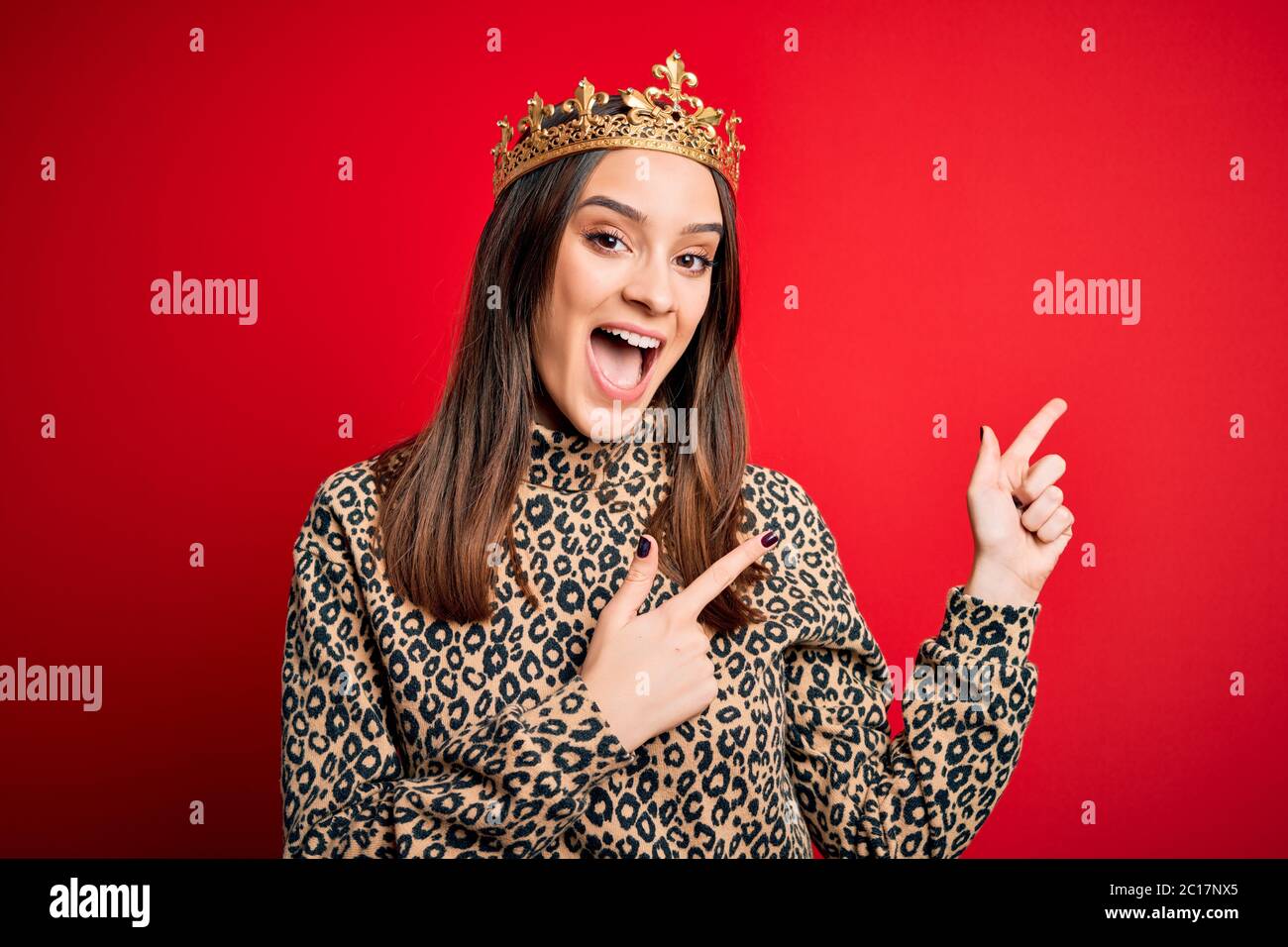 Young beautiful brunette woman wearing golden crown queen over isolated ...