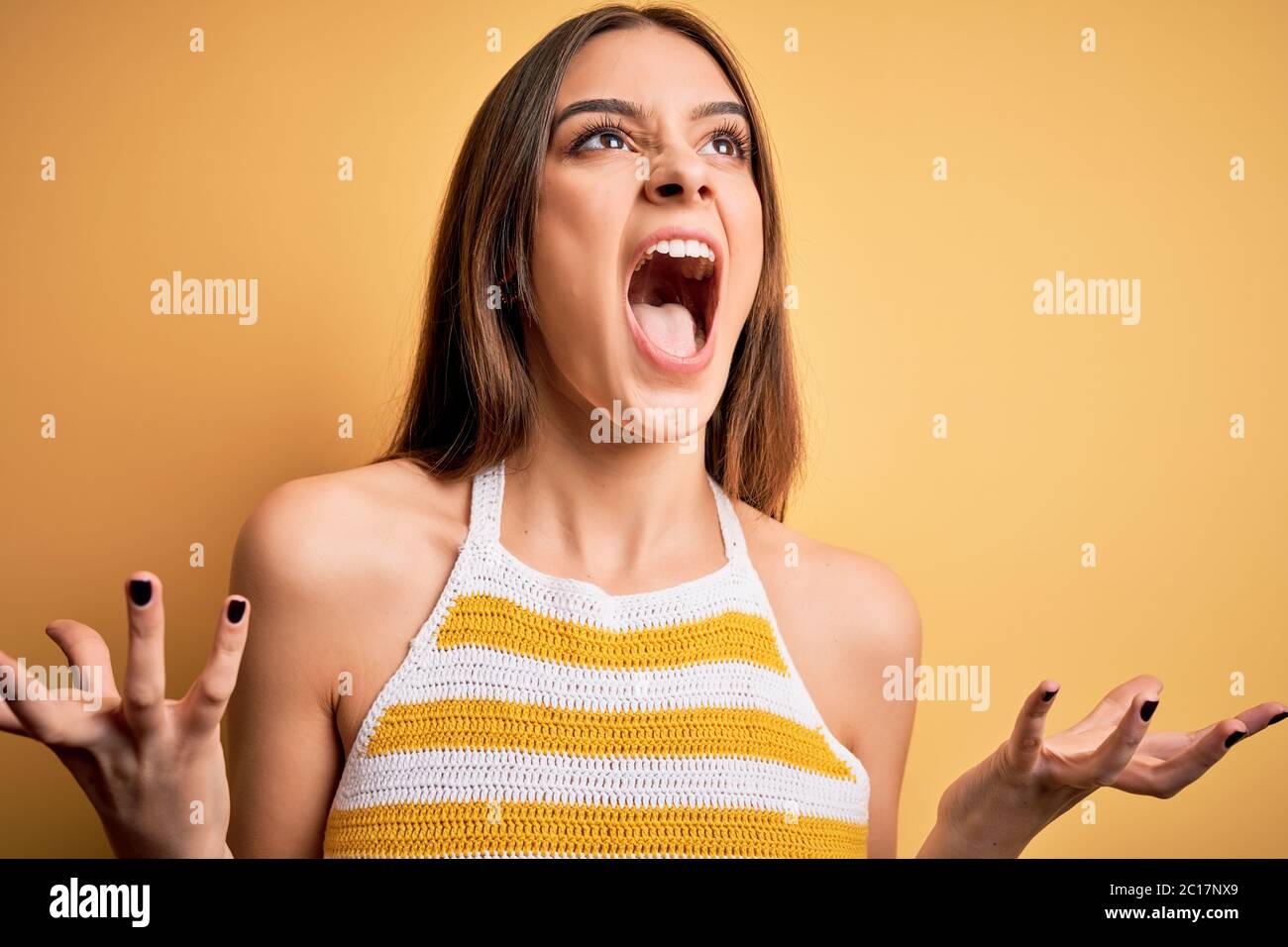 Young beautiful brunette woman wearing casual striped t-shirt over ...