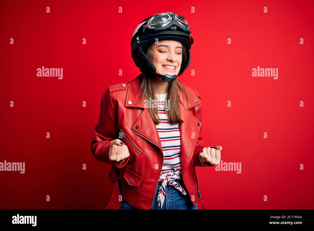 Young beautiful brunette motocyclist woman wearing motorcycle helmet ...