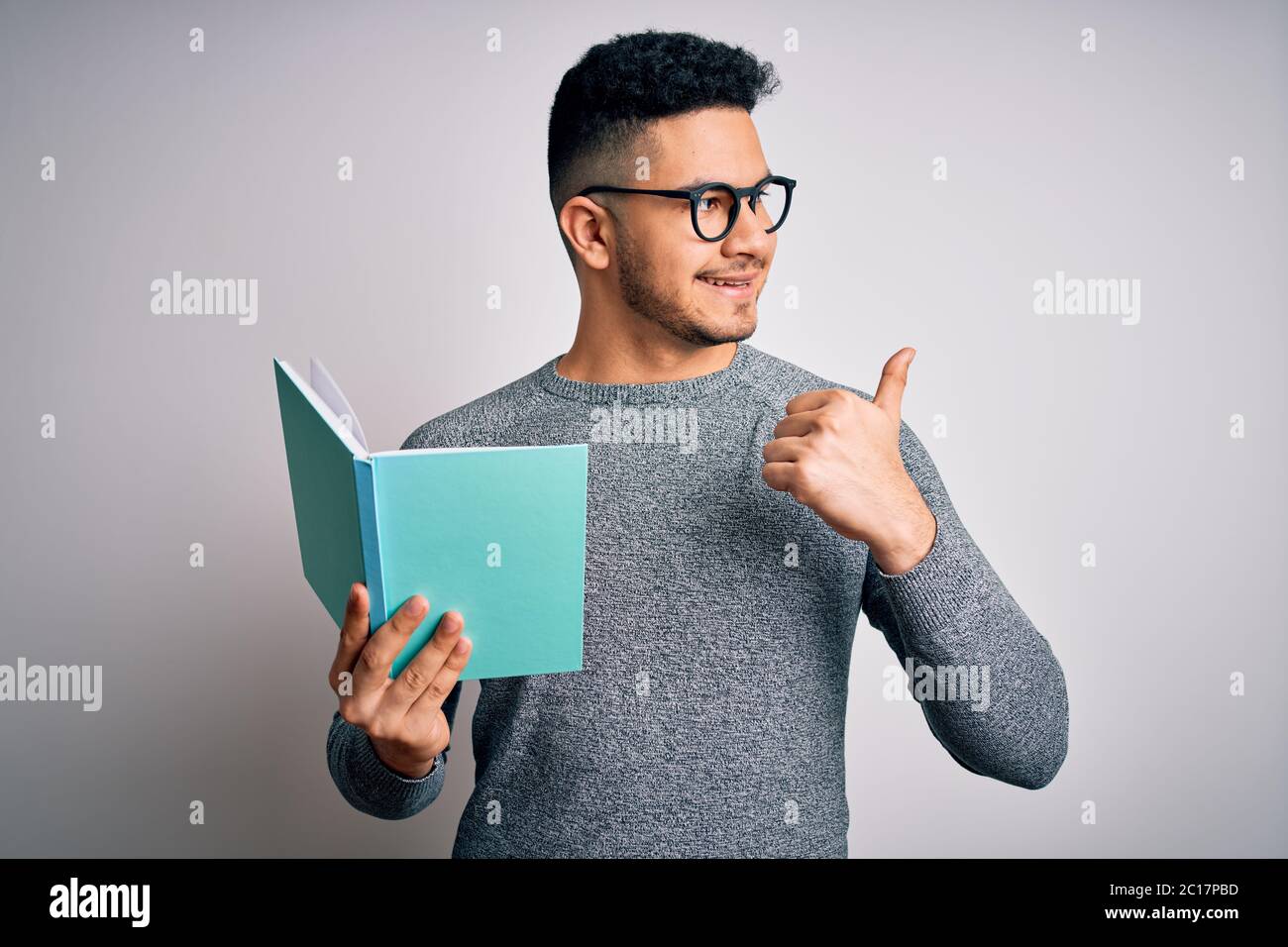 Young handsome smart student man reading book over isolated white ...