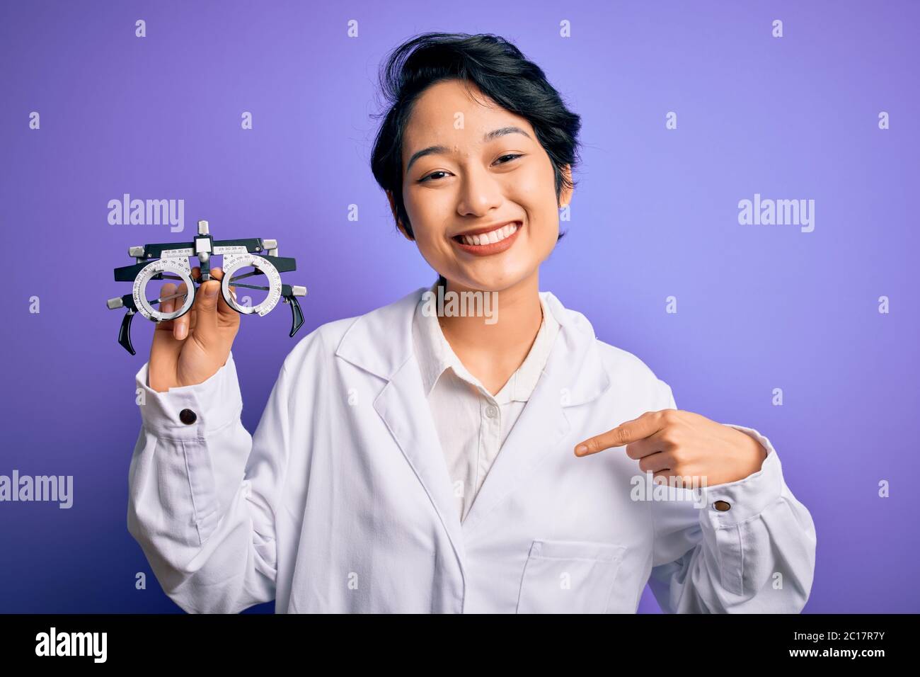 Beautiful asian optical girl wearing coat holding optometry glasses ...