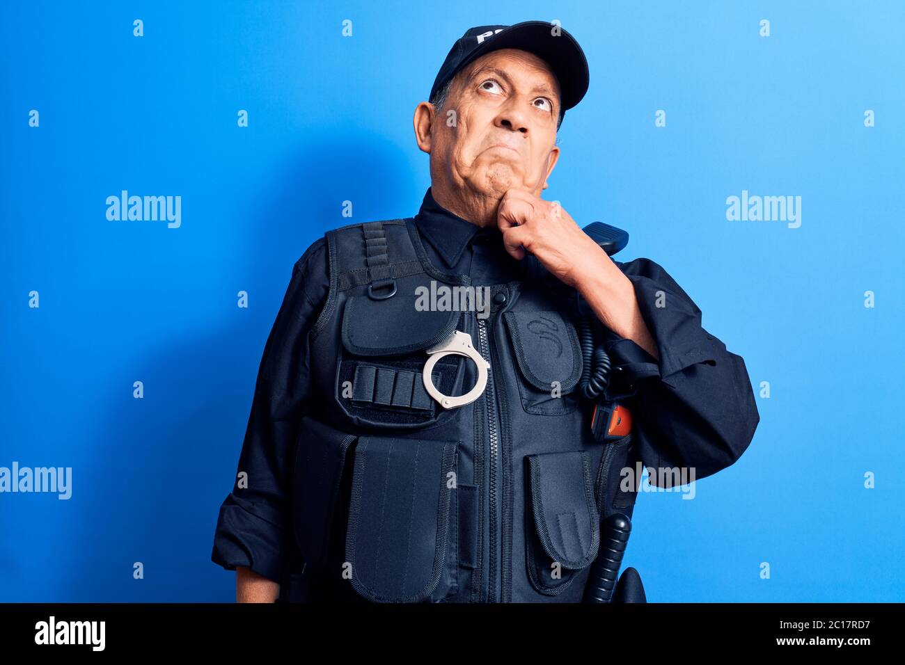 Senior man with grey hair wearing police uniform thinking concentrated ...
