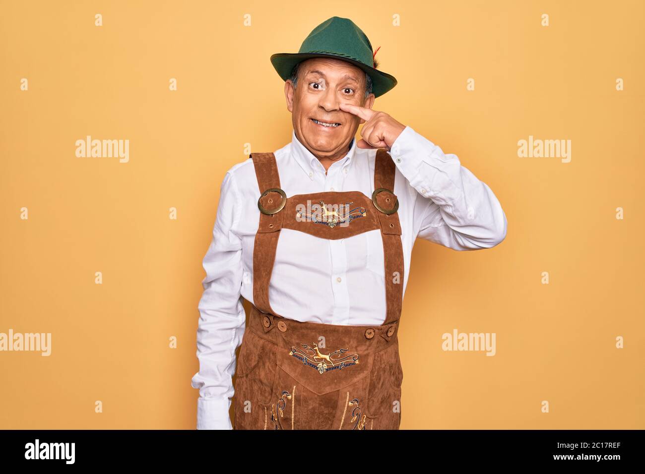 Senior grey-haired man wearing german traditional octoberfest suit over ...