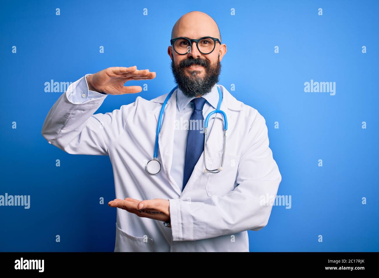 Handsome bald doctor man with beard wearing glasses and stethoscope ...