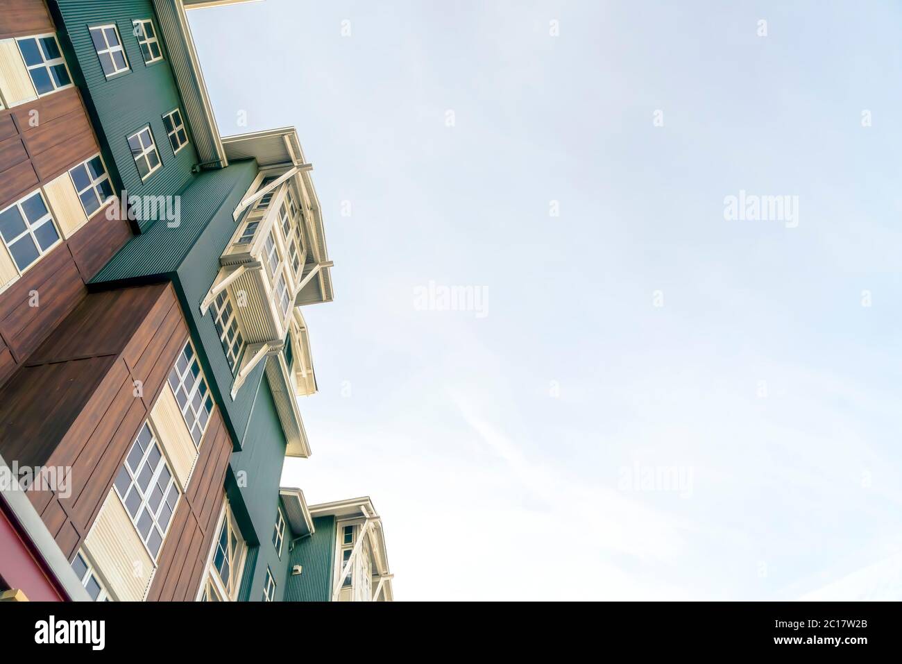 Residential building exterior viewed from below with cloudy sky ...