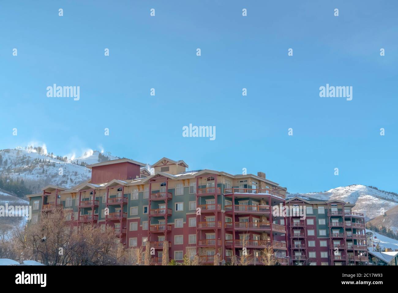 Residential building facade with snowy mountain and blue sky background ...