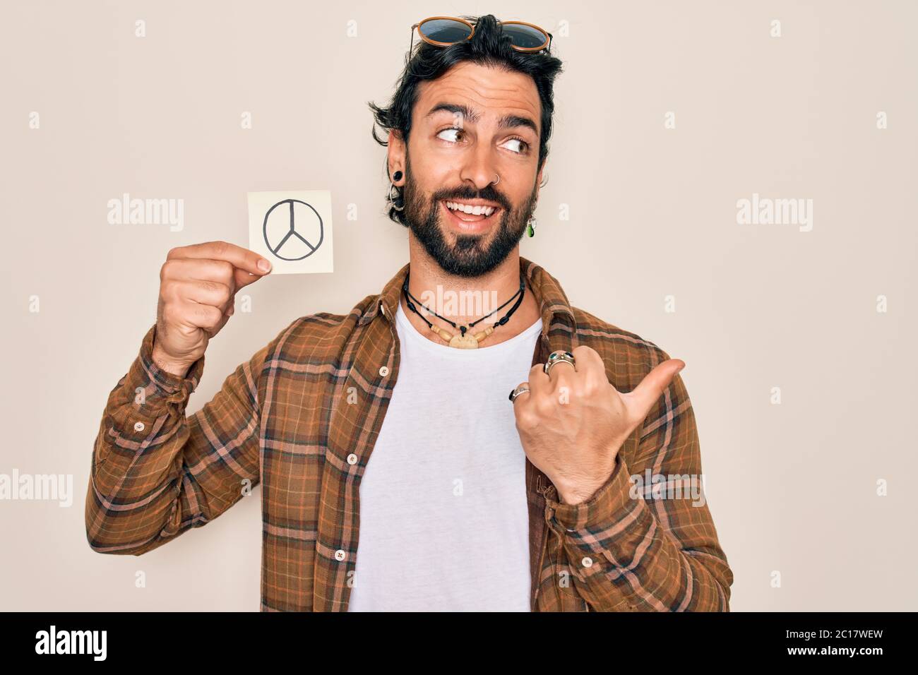 Young handsome hispanic bohemian hipster man with bear holding paper ...
