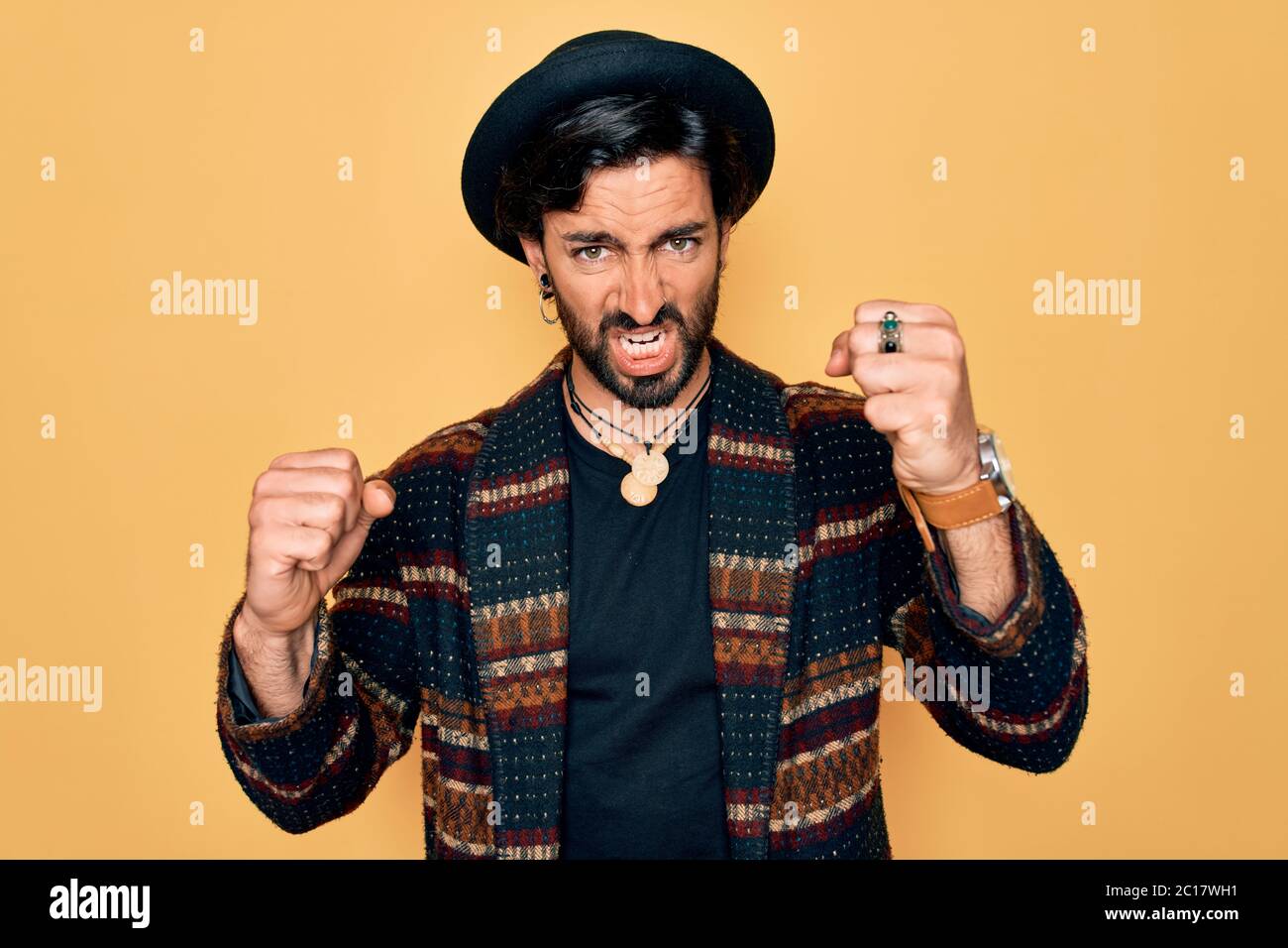 Young handsome hispanic bohemian man wearing hippie style and boho hat ...