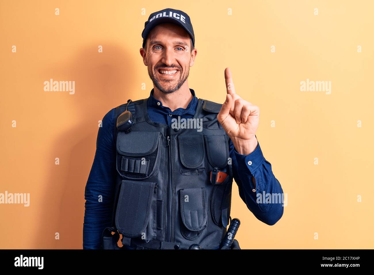 Young handsome policeman wearing police uniform and bulletprof over ...