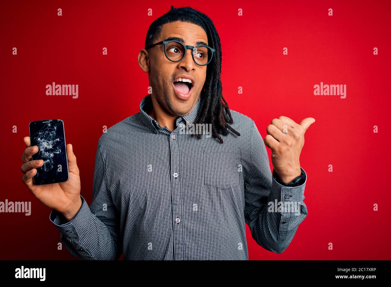 Young african american afro man holding broken smartphone showing ...