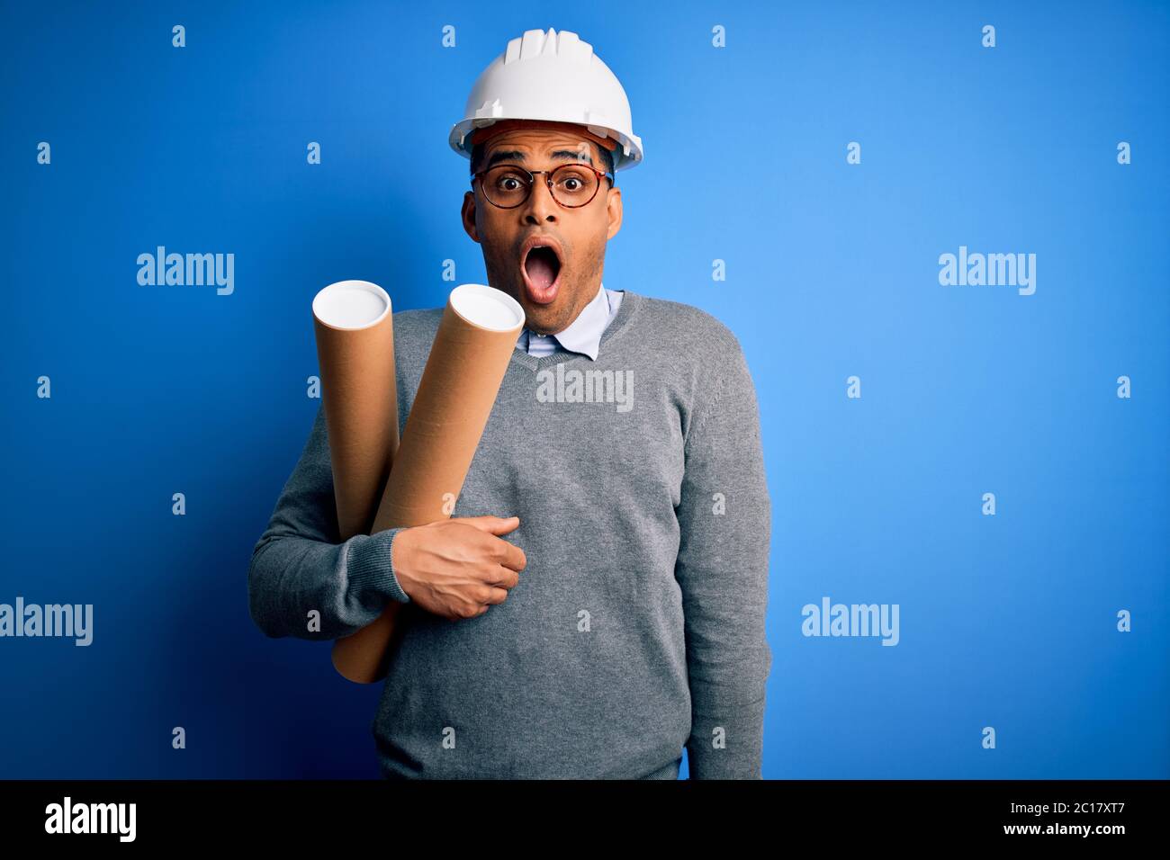 Young african american afro architect man wearing safety helmet holding ...