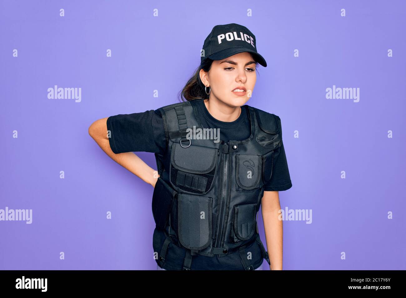 Young police woman wearing security bulletproof vest uniform over ...