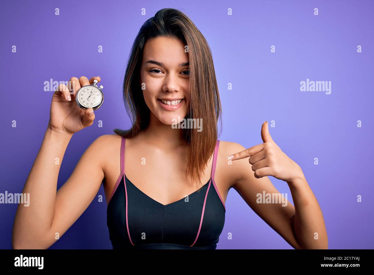 Young beautiful sporty girl doing sport using stopwatch over isolated ...