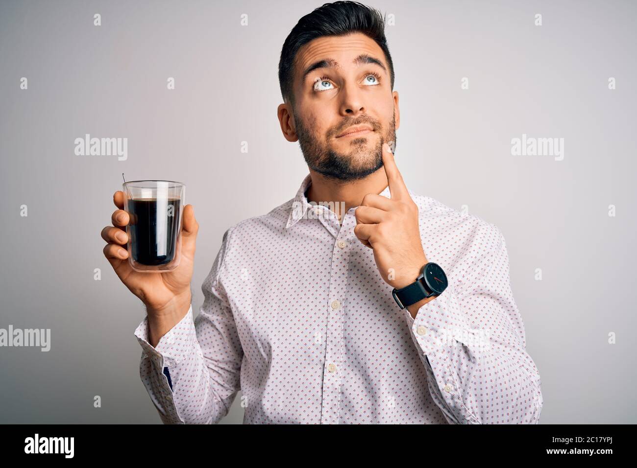 Young handsome man drinking a cup of hot coffee over white isolated ...