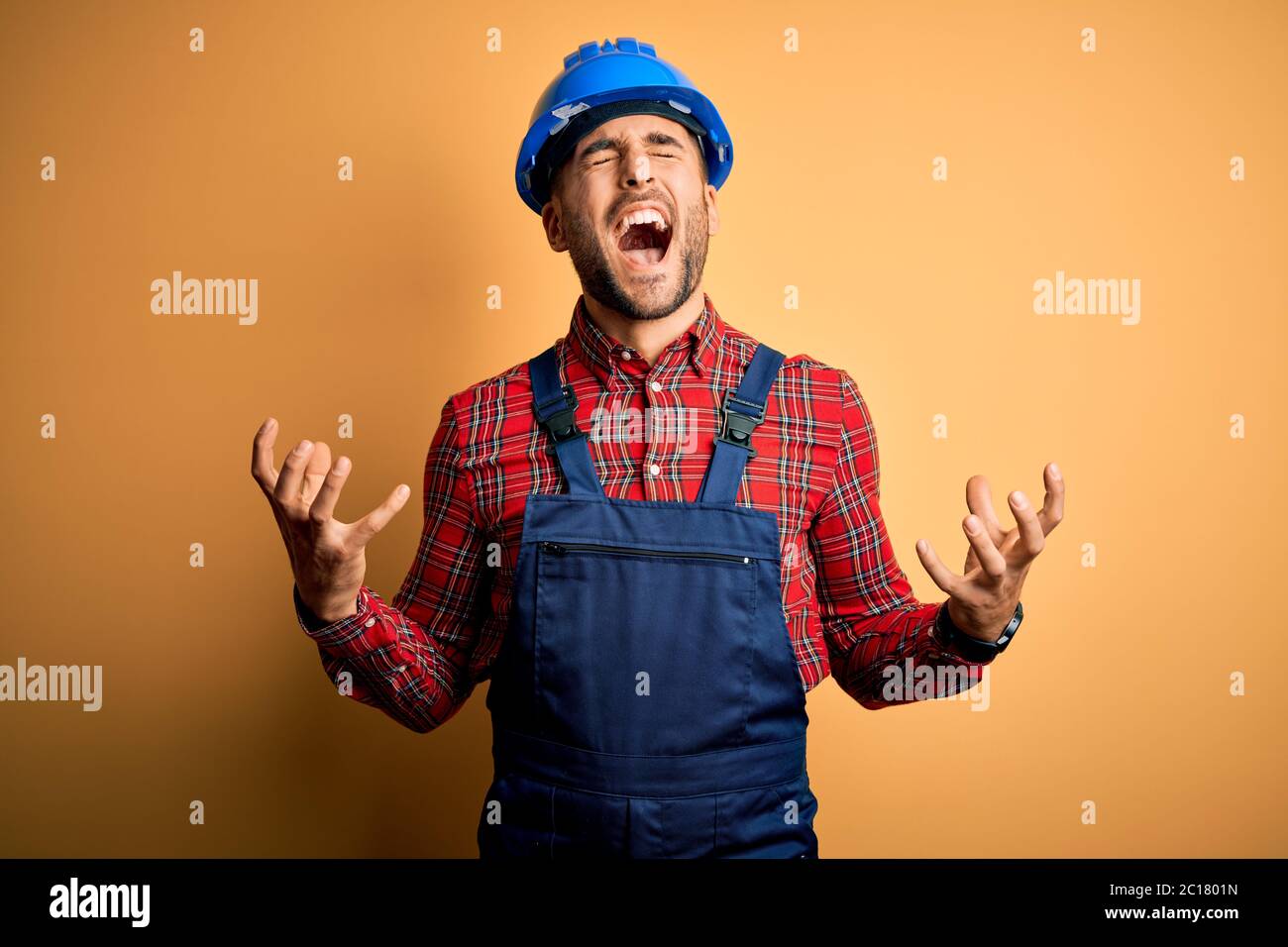 Young builder man wearing construction uniform and safety helmet over ...