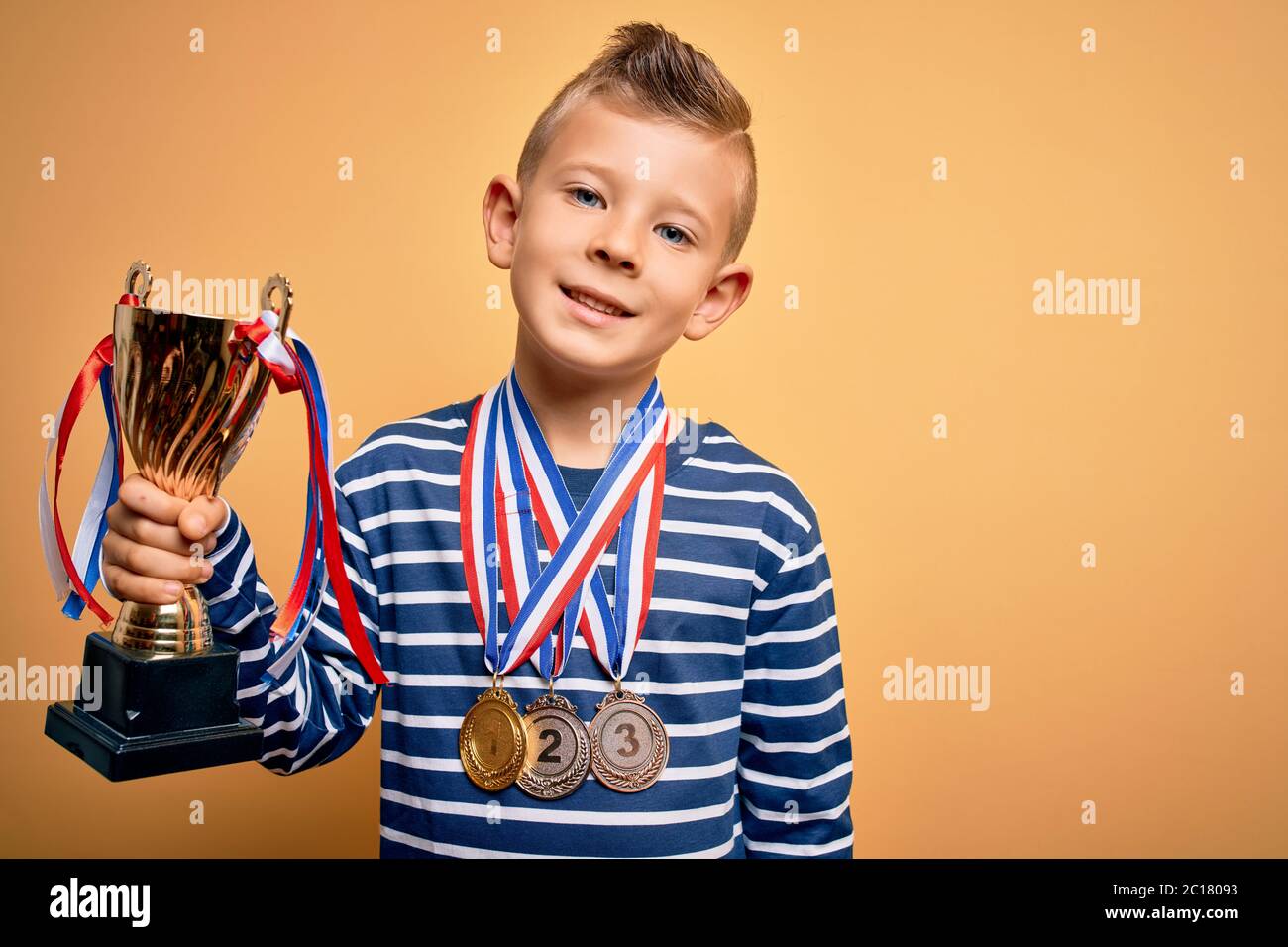 Young little caucasian kid wearing winner medals and victory award ...
