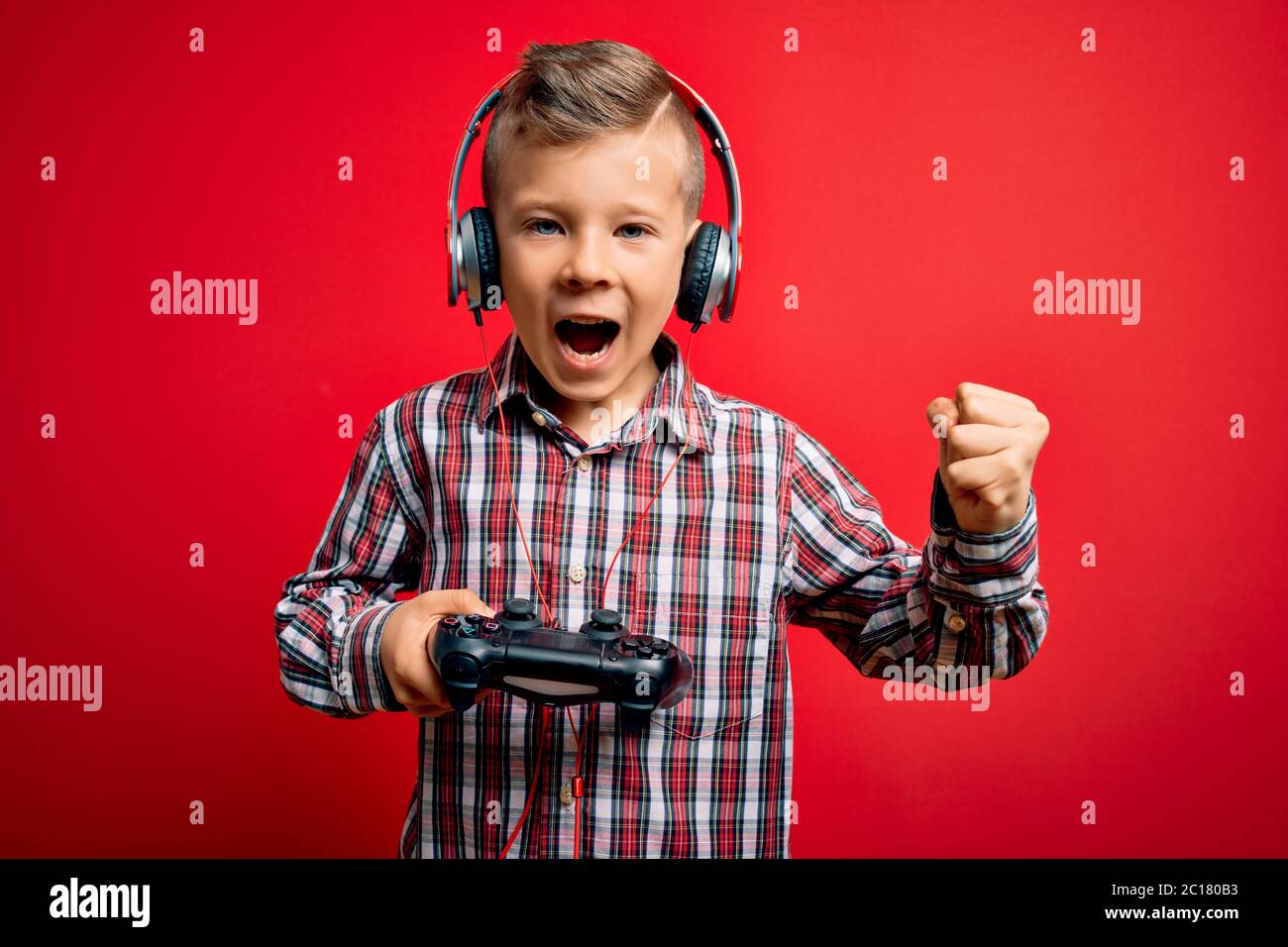Young little caucasian gamer kid playing video games using gamepad ...