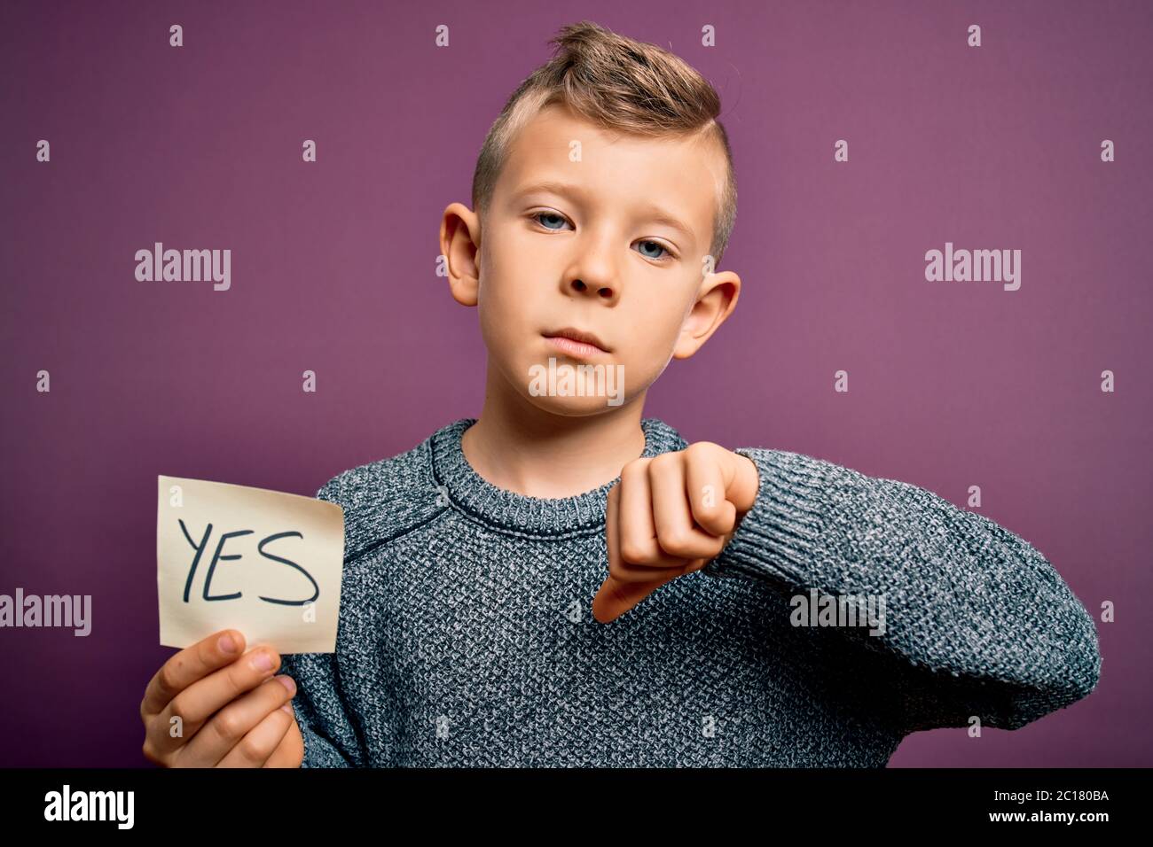 Young little caucasian kid showing YES word on a paper note as positive ...