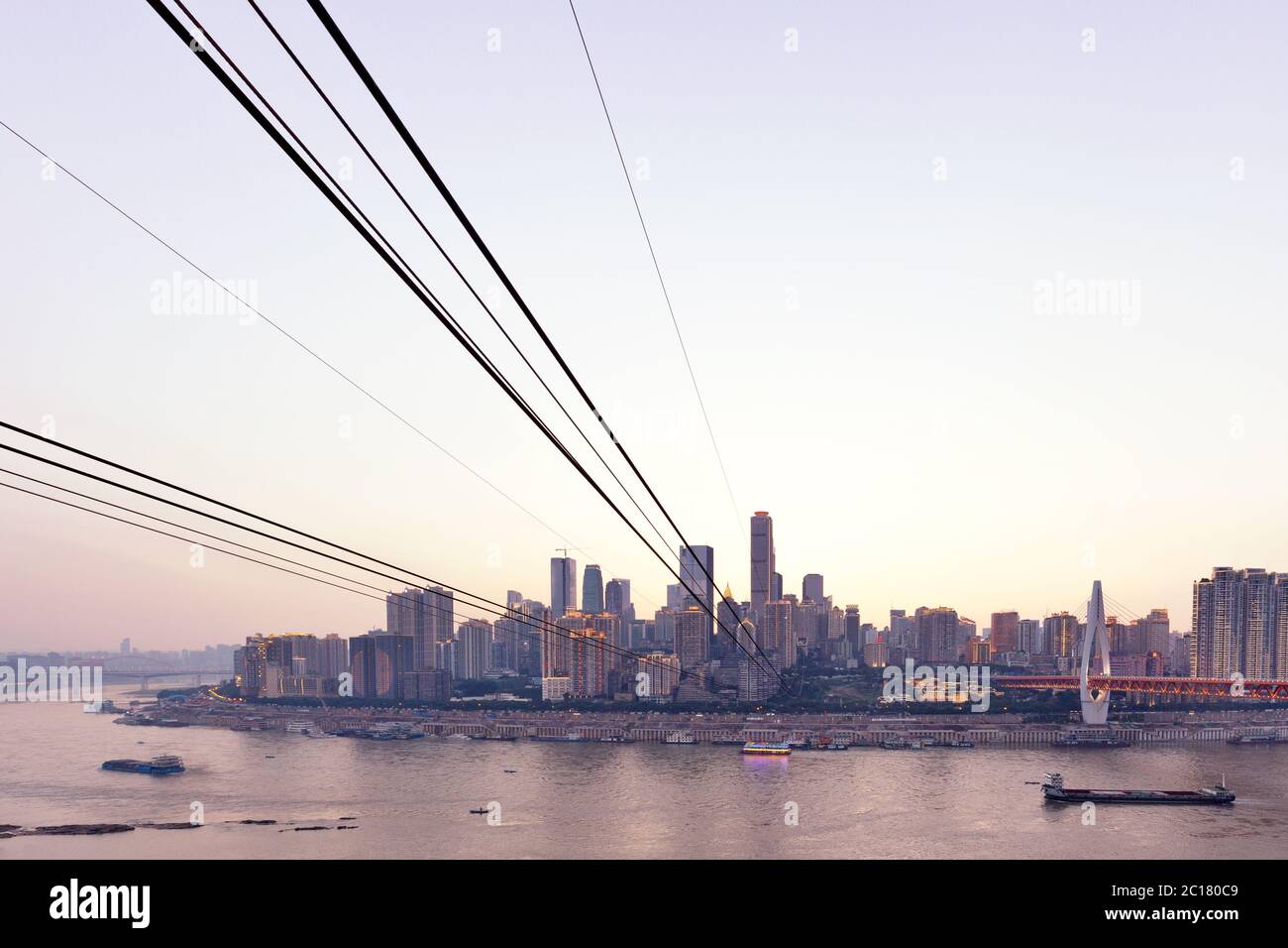steel cable over river to modern city at twilight Stock Photo - Alamy