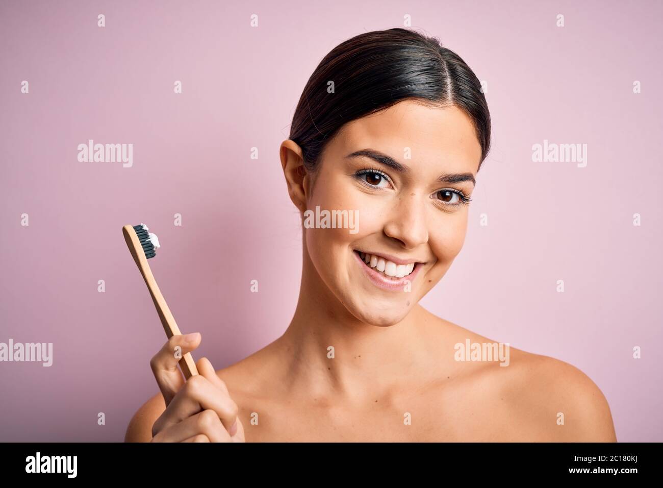 Young beautiful brunette woman brushing her teeth using tooth brush and ...