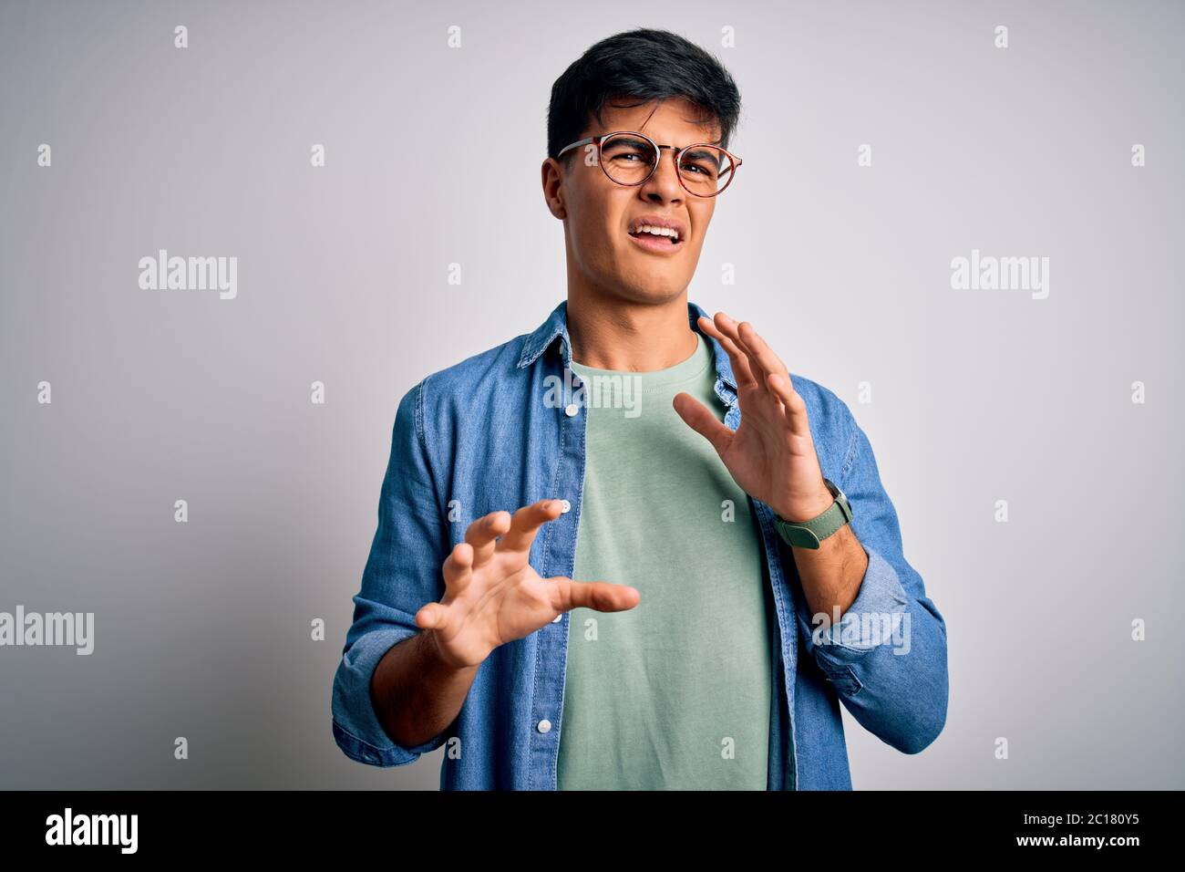 Young handsome man wearing casual shirt and glasses over isolated white ...