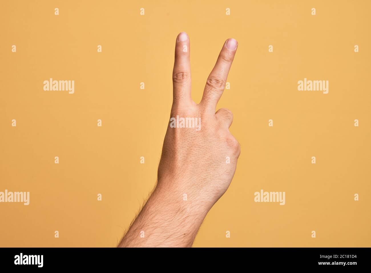 Hand of caucasian young man showing fingers over isolated yellow ...