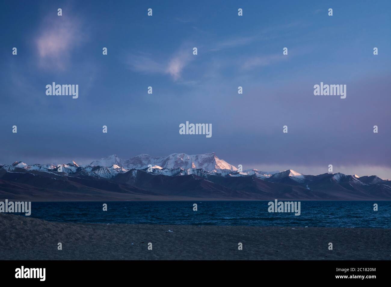 The Nyenchen Tangula mountain range seen across Nam lake at sunset ...