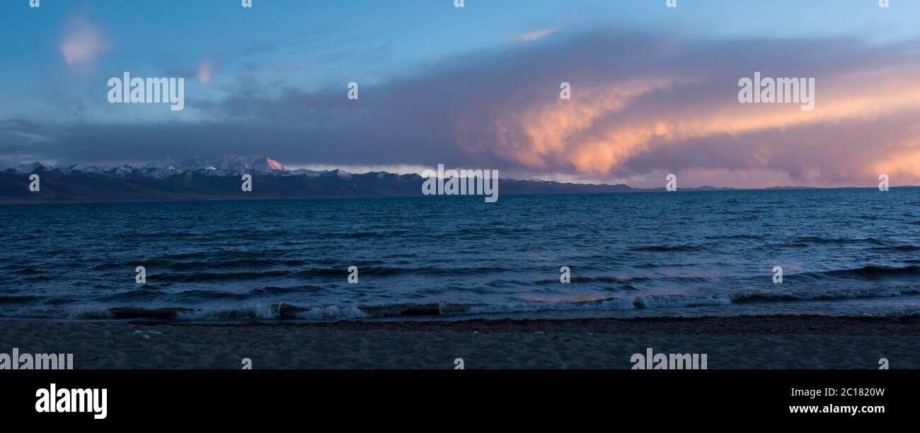The Nyenchen Tangula mountain range seen across Nam lake at sunset ...