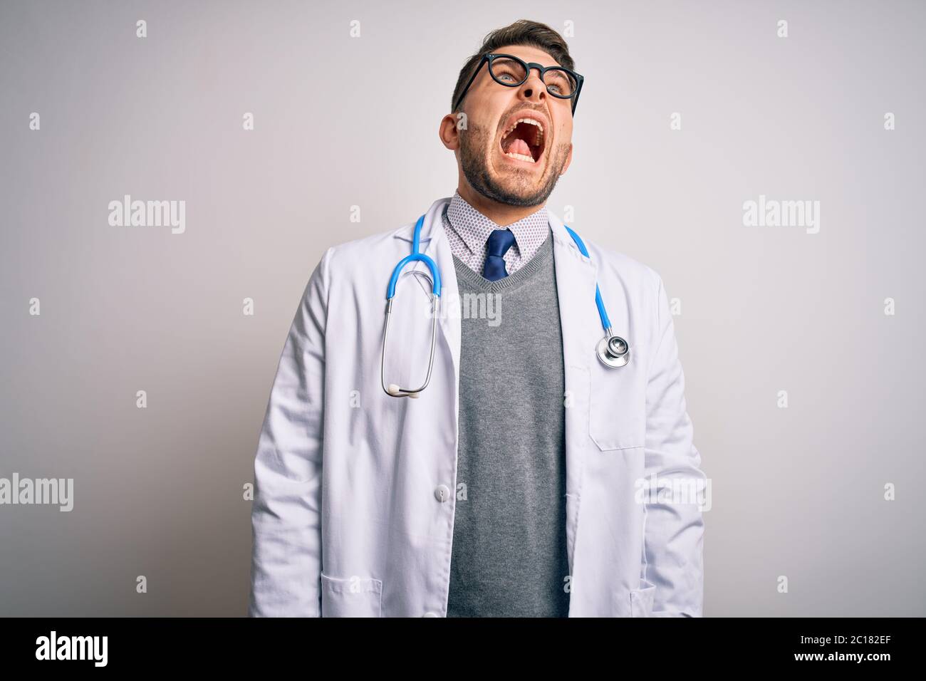 Young doctor man with blue eyes wearing medical coat and stethoscope ...