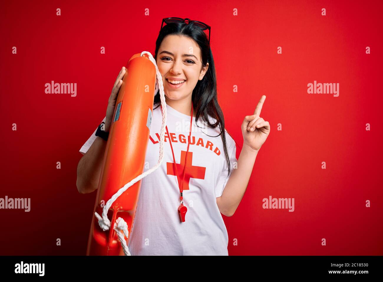Young lifeguard woman wearing secury guard equipent holding rescue ...