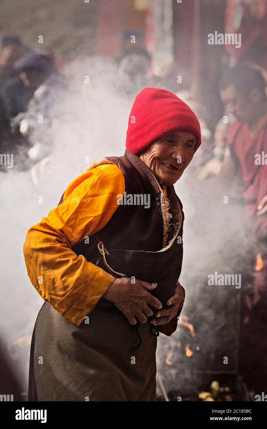 An old pilgrim arrives to the Tsurphu monastery festival in the midst ...