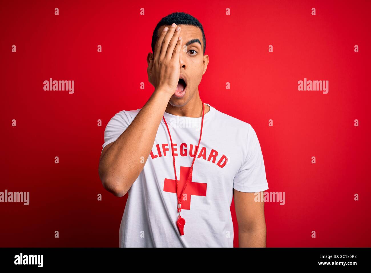 Young handsome african american lifeguard man wearing t-shirt with red ...